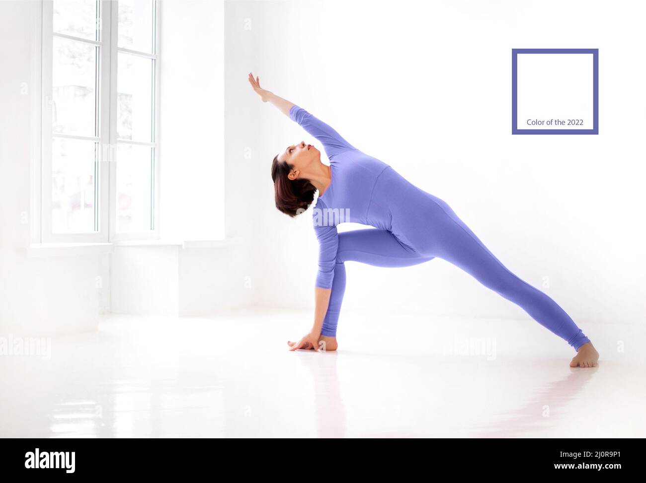 Young slender fit woman in very peri long bodysuit performing yoga pose ...