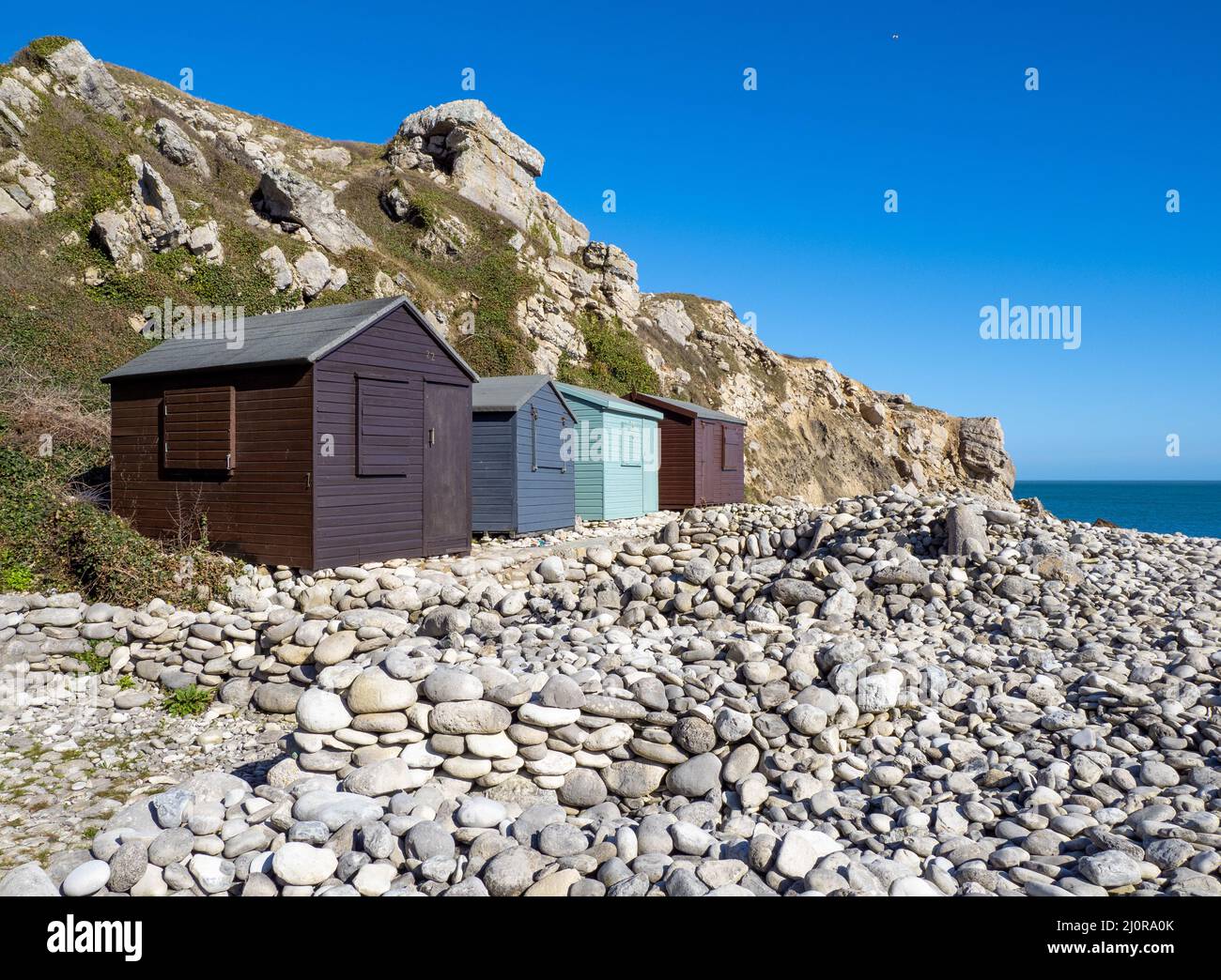 Beach huts at Church Ope Cove a secluded beach and shingle bank on the ...