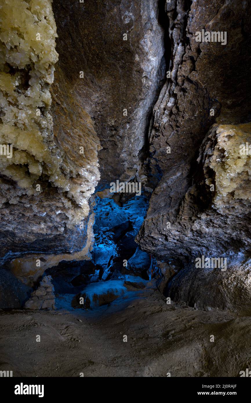 Interior of the cave with blue light and crystal. Tourist hiking route ...