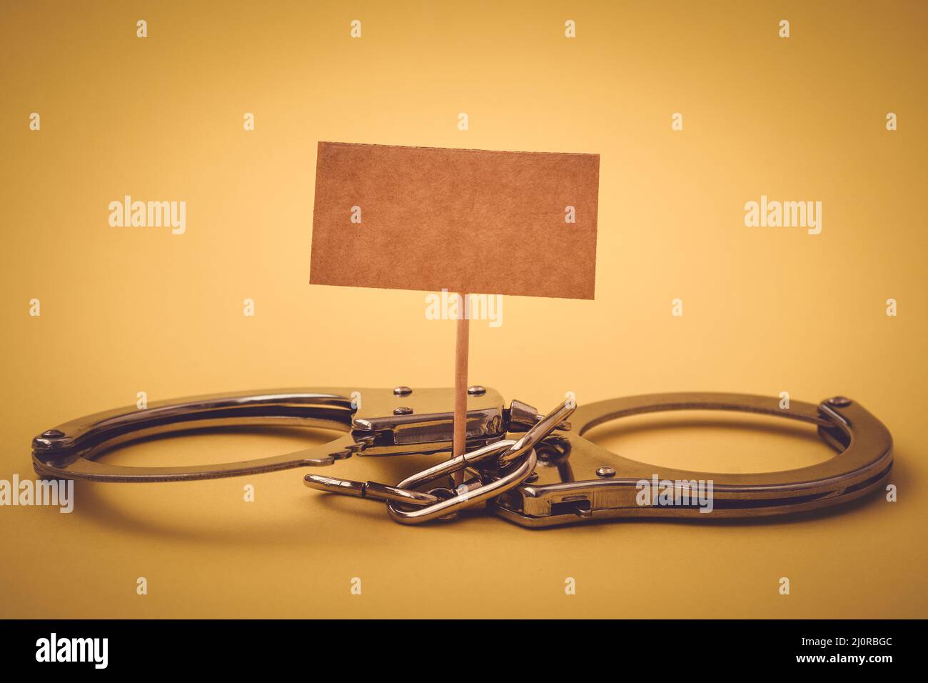 Handcuffs and blank banner mock up on wood stick Stock Photo - Alamy