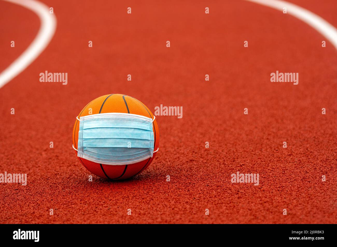 Basketball ball on the running track of empty stadium with medical face ...