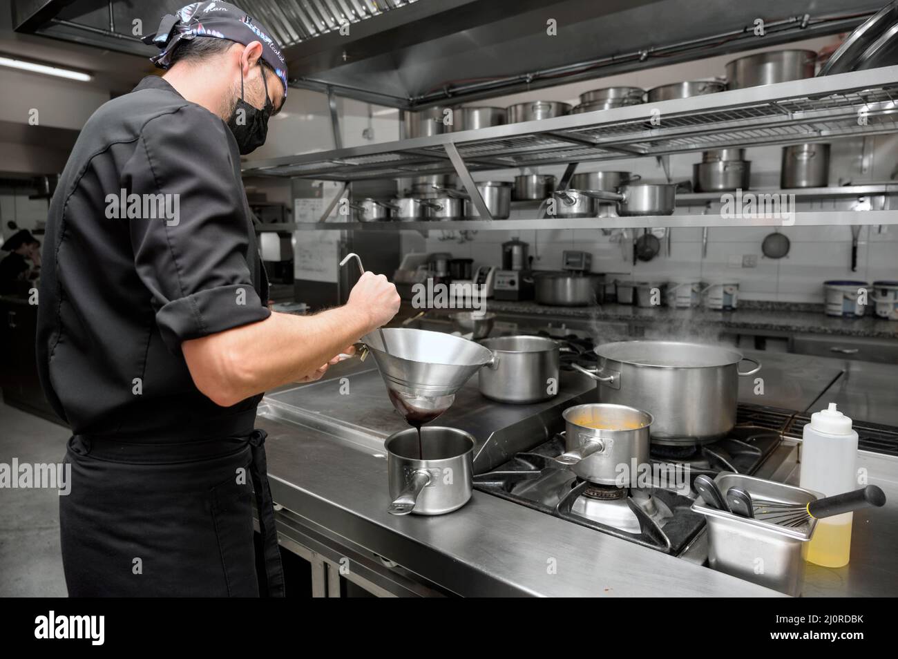 Chef cooking in modern industrial kitchen Stock Photo - Alamy
