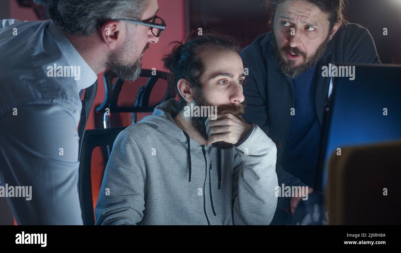 Three employees cooperating in office talking working together at ...