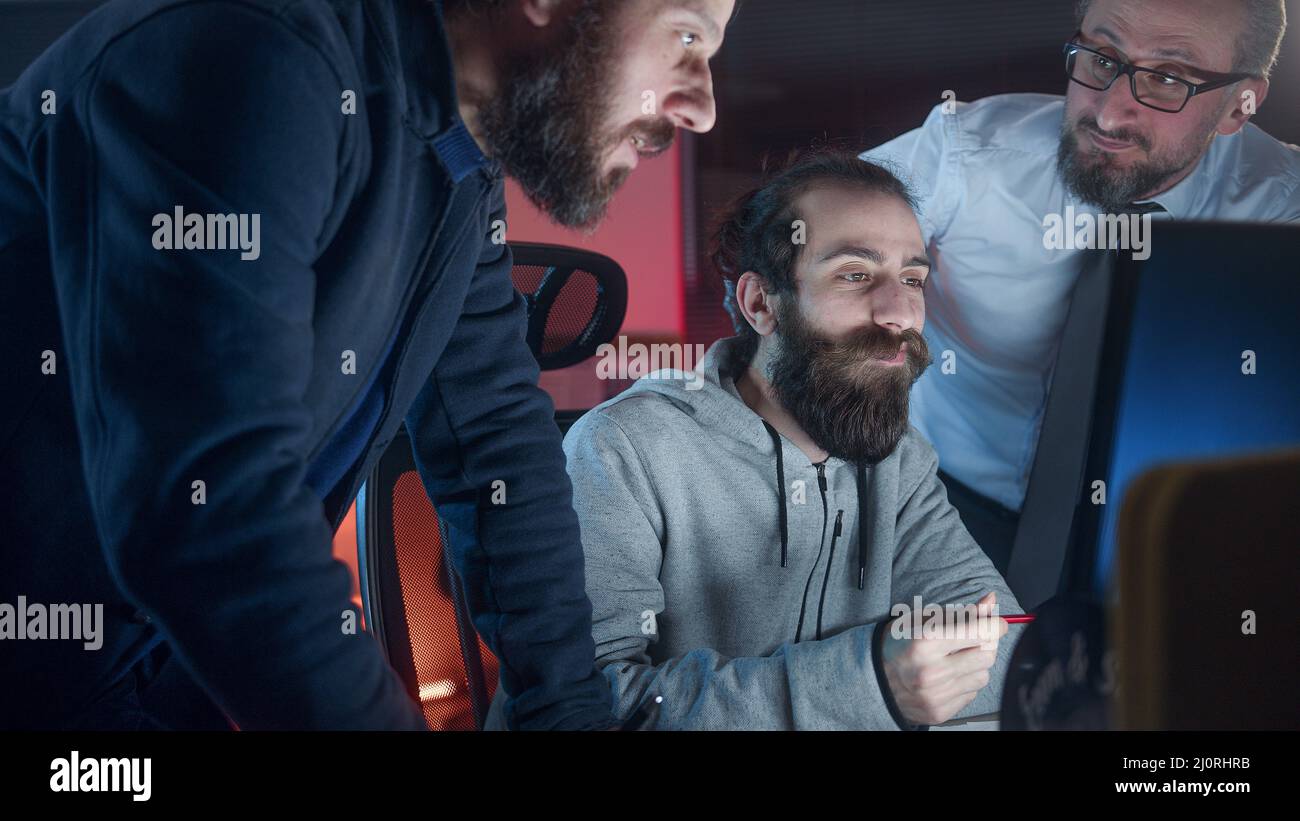 Three male colleagues employees cooperating in office talking working ...