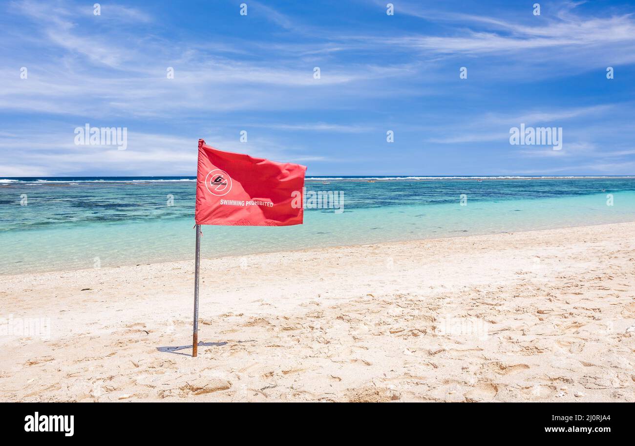 Red flag warning on sandy beach in Bali Stock Photo - Alamy