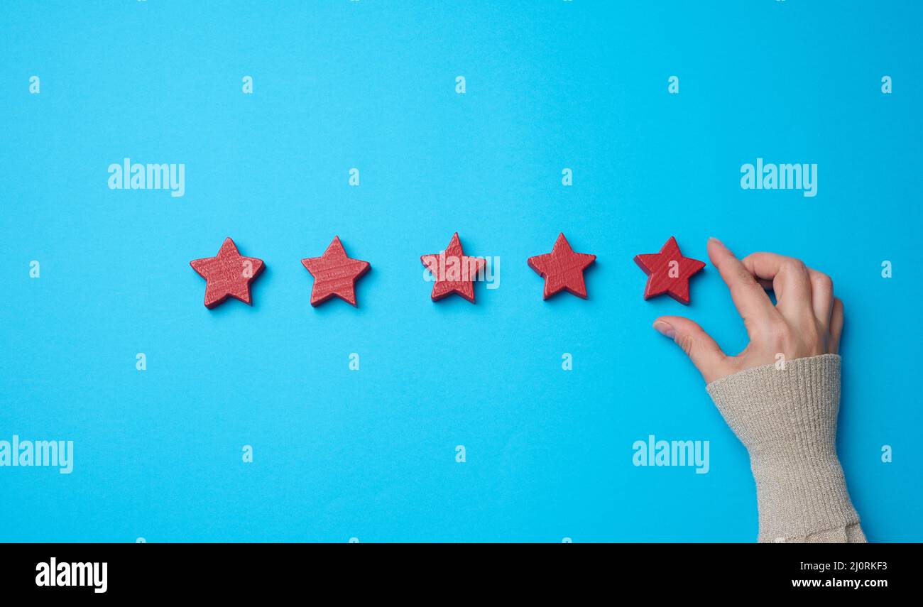 Five red stars and a hand on a blue background. Evaluation of the ...