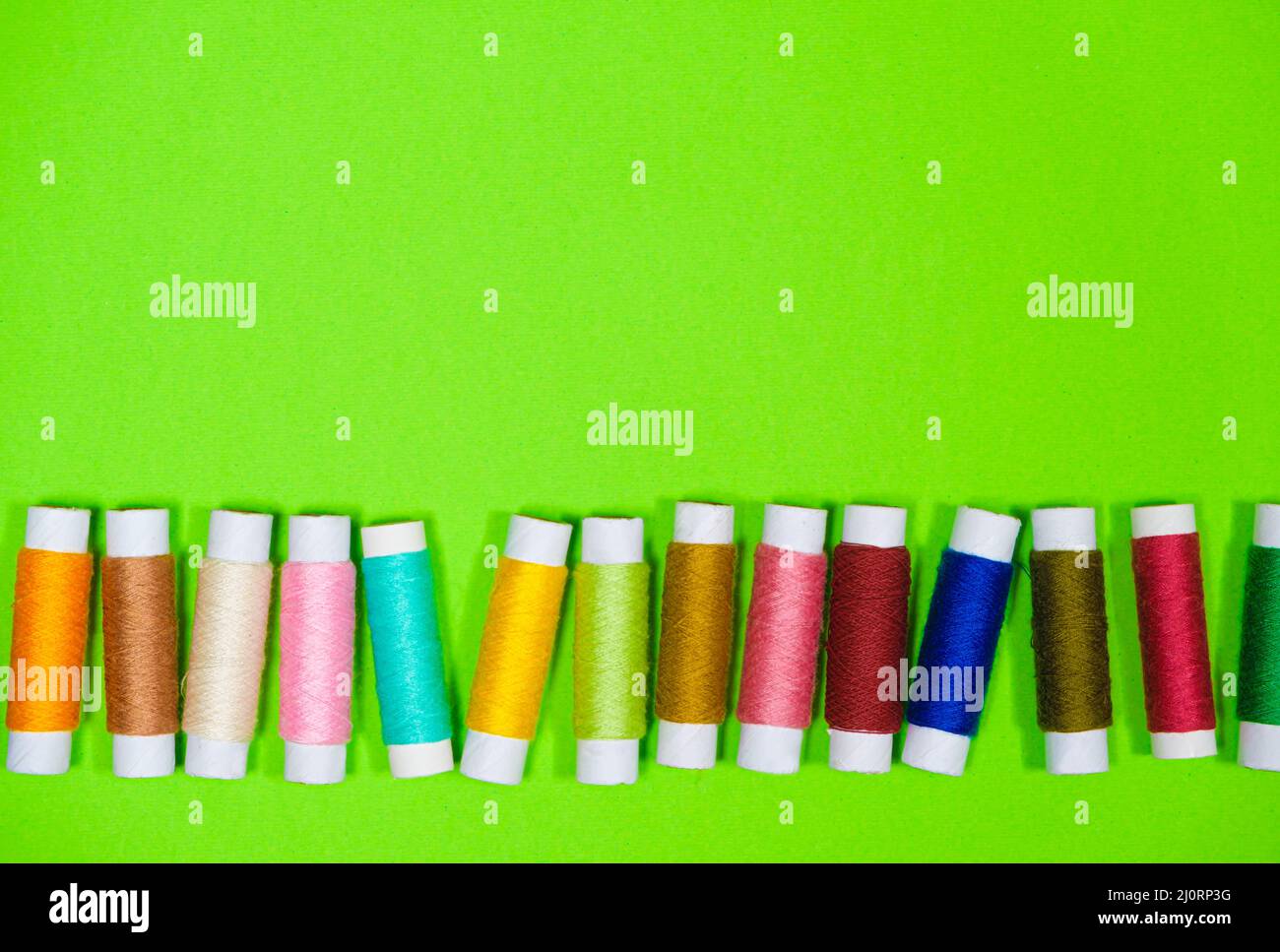 A set of multi-colored threads for sewing with an empty space for text ...