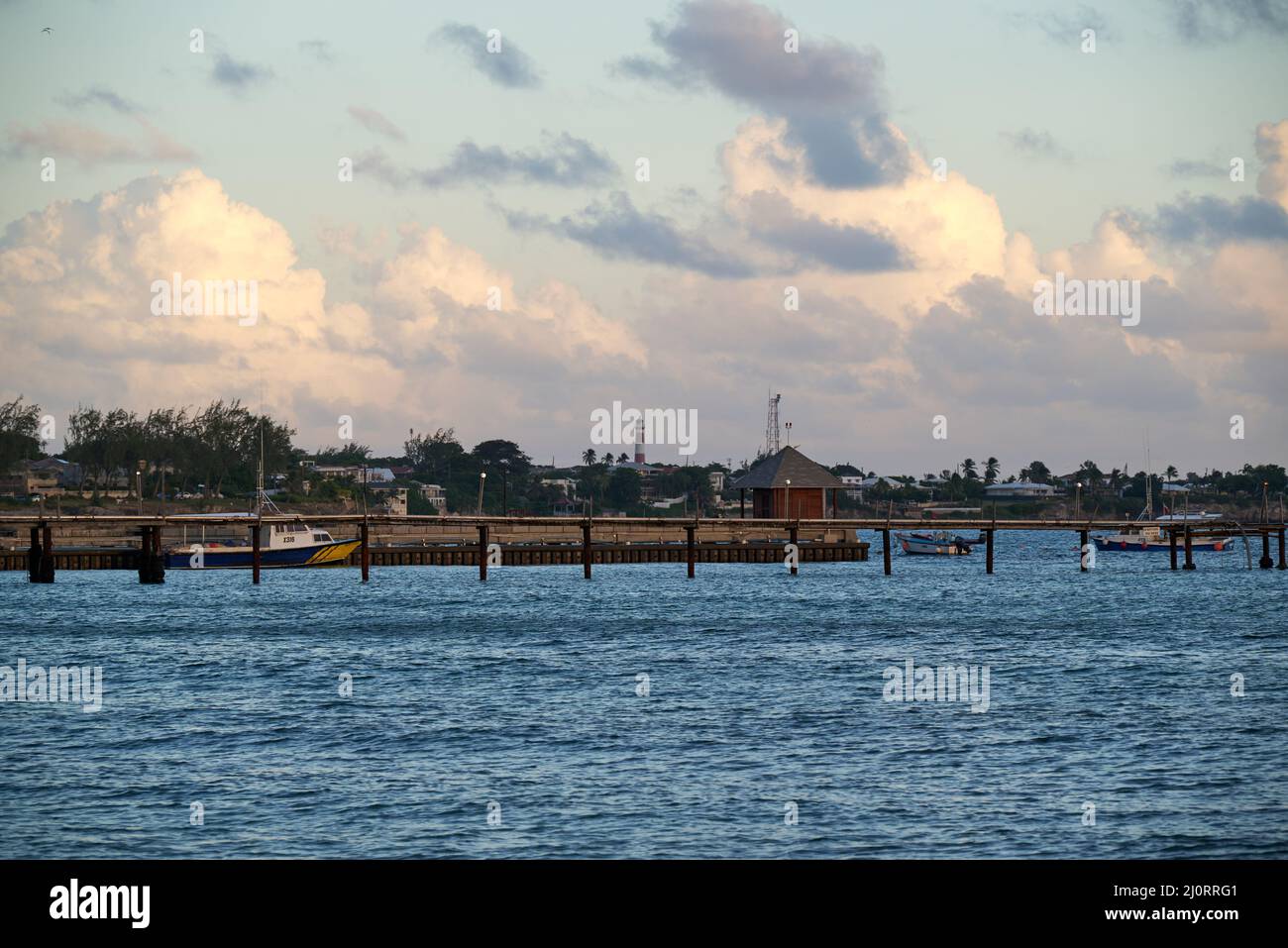 Beautiful scenery of a peaceful harbor with boats and wooden bridge in ...