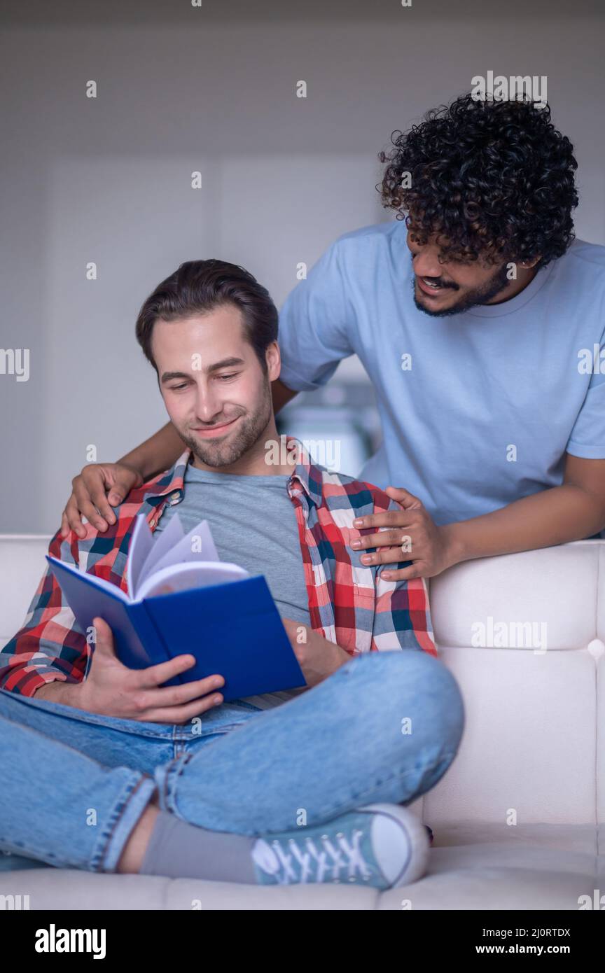 Man reading a book in presence of his boyfriend Stock Photo - Alamy