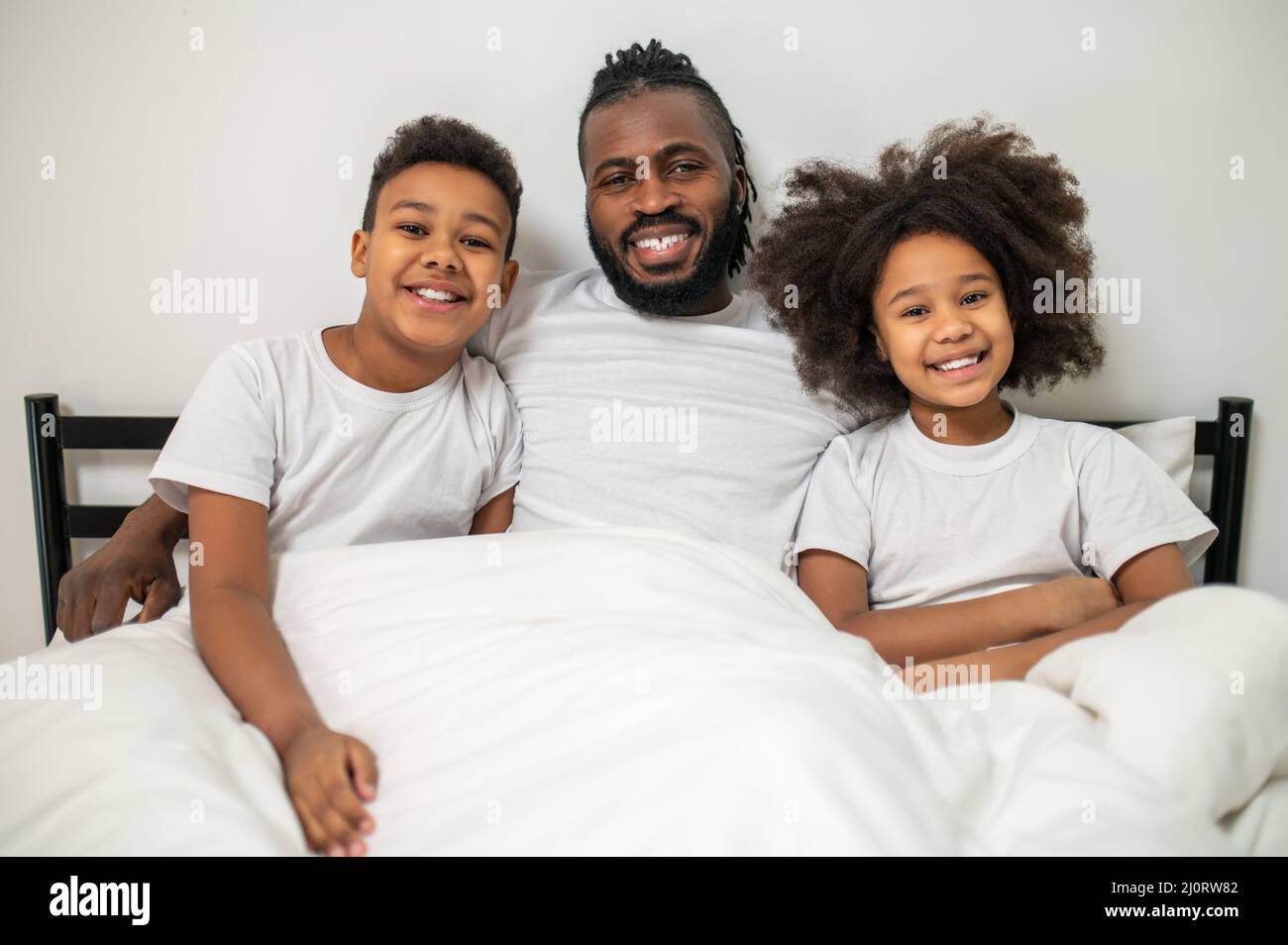 Man hugging son and daughter looking at camera Stock Photo - Alamy