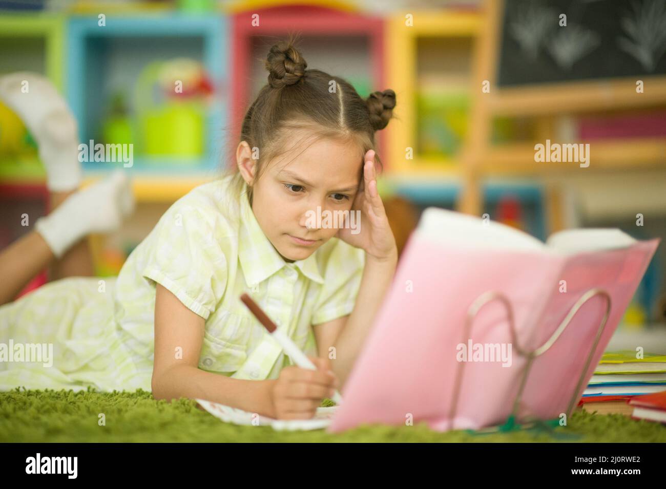 Portrait of cute little girl studying at home Stock Photo - Alamy