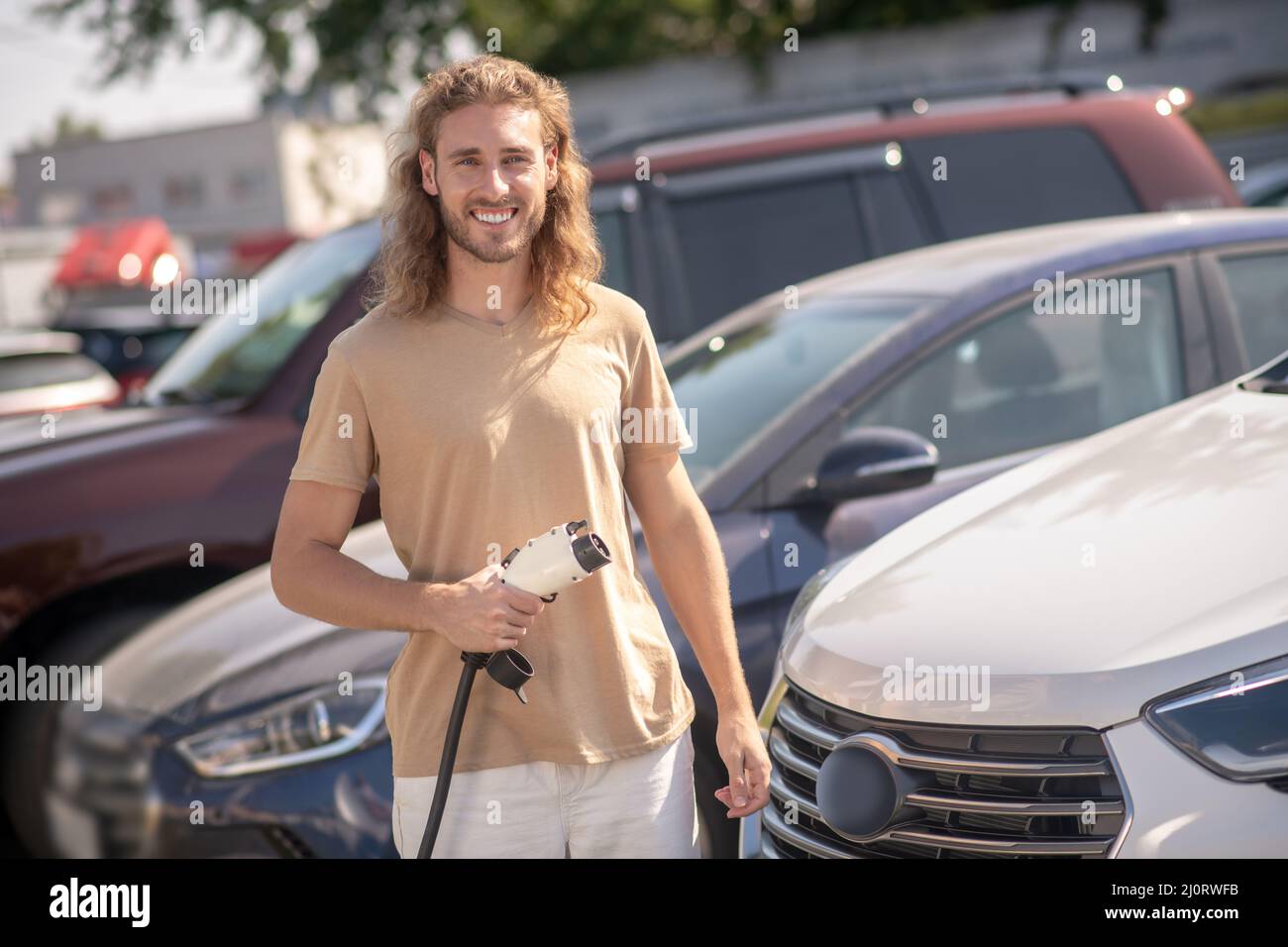 Man standing near car smiling at camera Stock Photo - Alamy