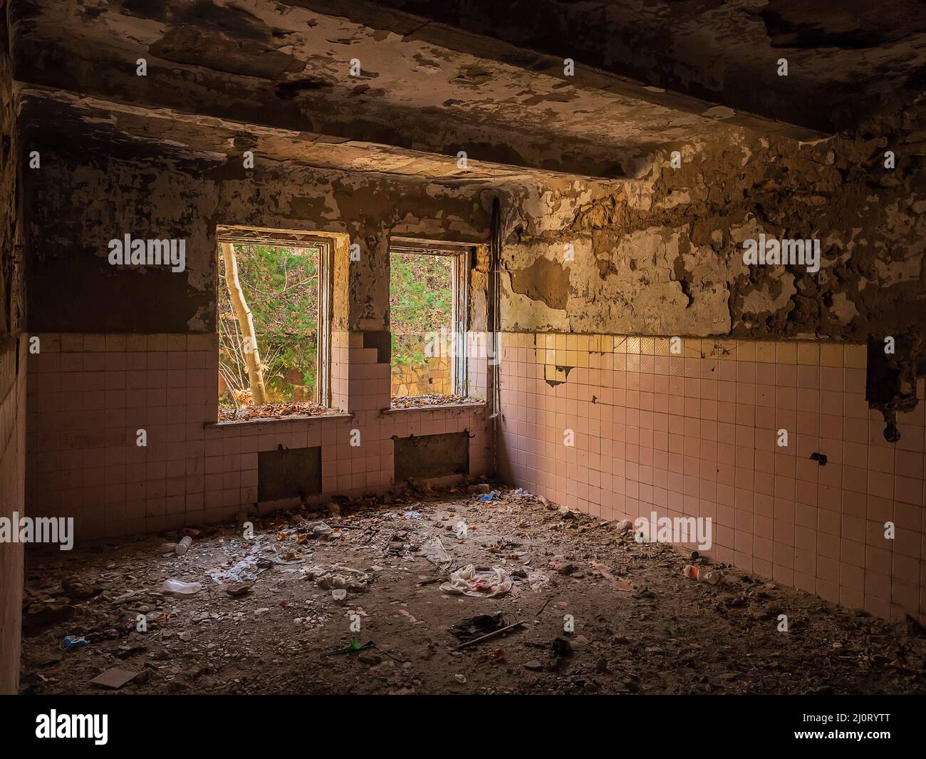 A shabby ruined room of an old abandoned building with remnants of ...