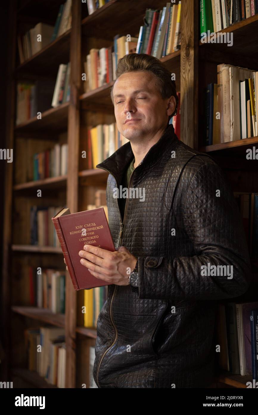 Handsome Aristocratic Man with Delicate Features Stands by a Bookcase ...