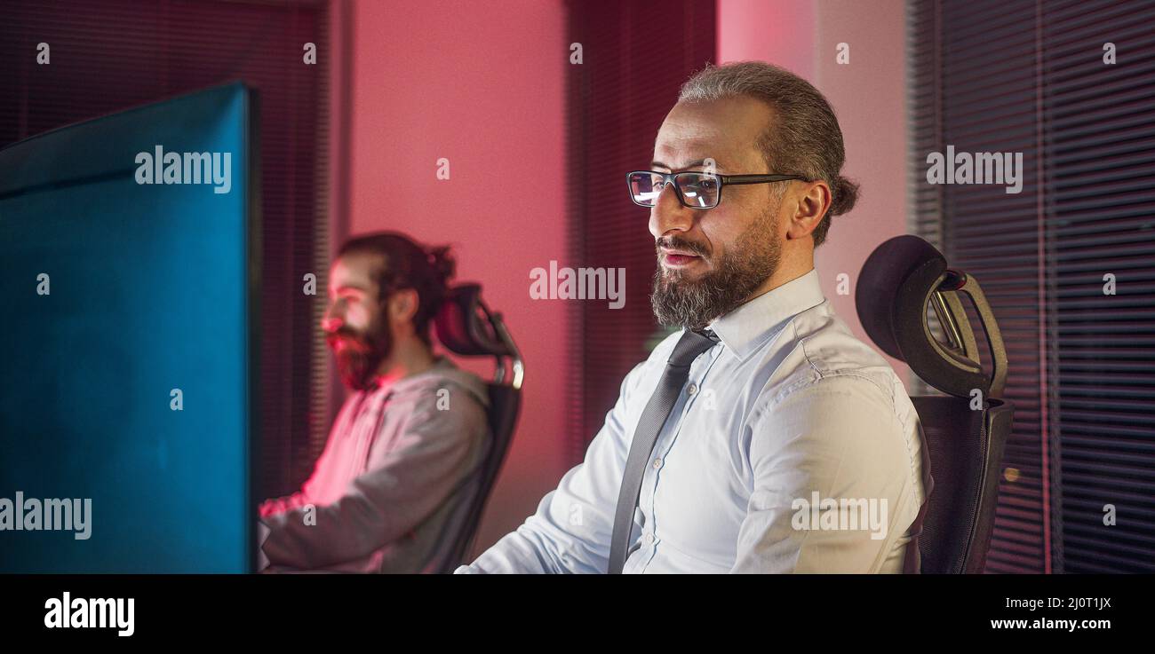 Middle-aged company CEO or boss is training his trainee, trying to help ...