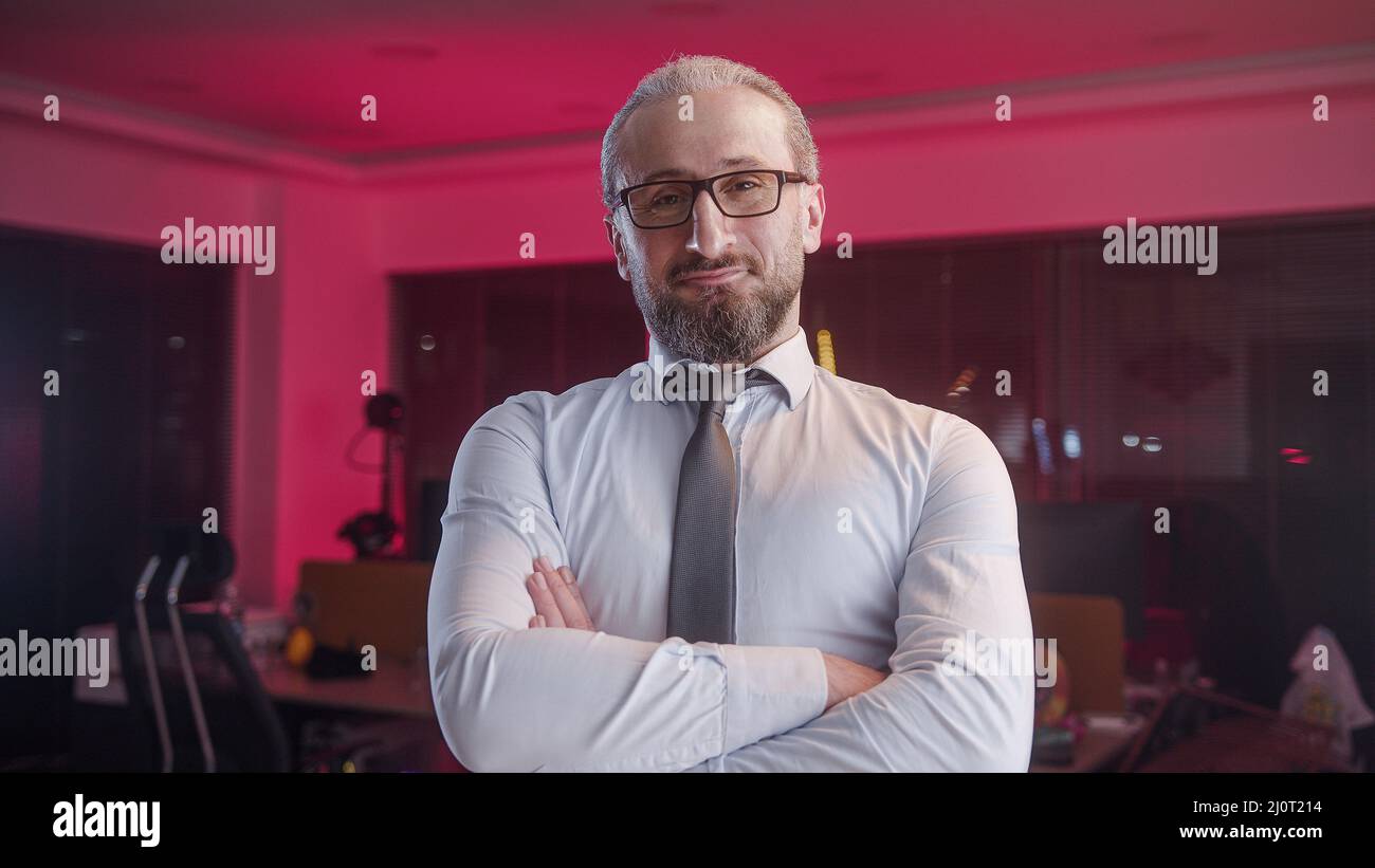 Portrait of bearded middle-aged top manager in office suit and glasses ...