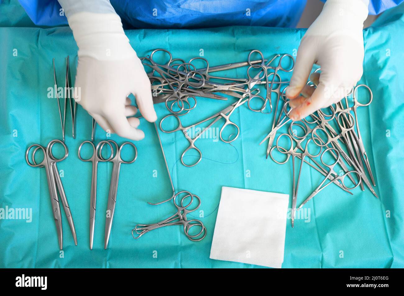 Multiple surgery instruments on blue table above view. surgeon take ...