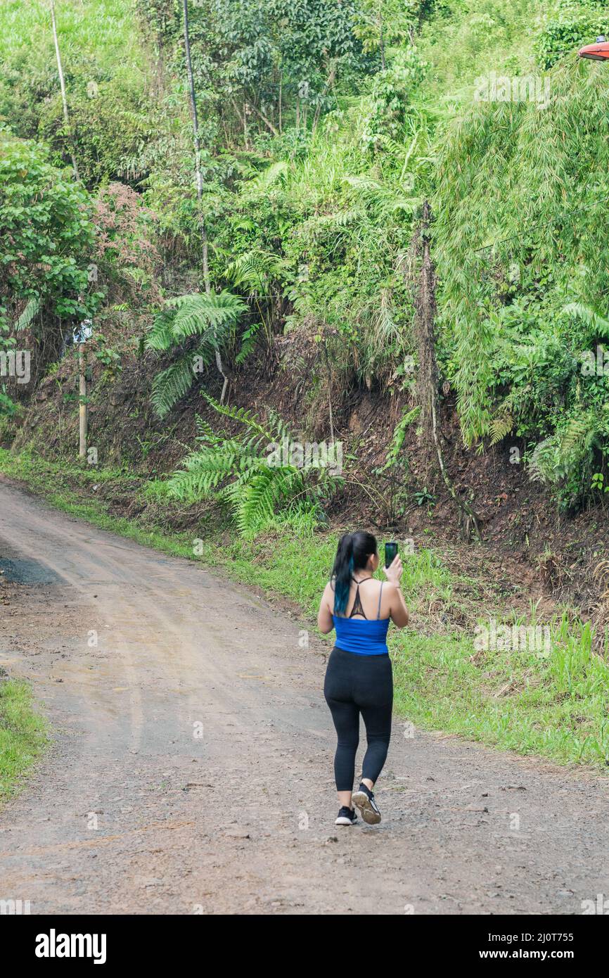 beautiful latin girl walking along a trail in the middle of a forest in ...