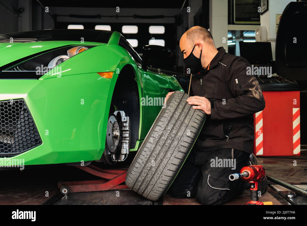 Mechanic changing the wheel of a high-end super sports car Stock Photo ...