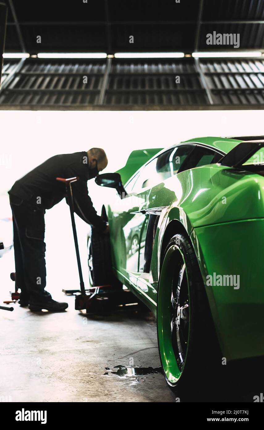 Mechanic changing the wheels of a high-end super sports car Stock Photo ...
