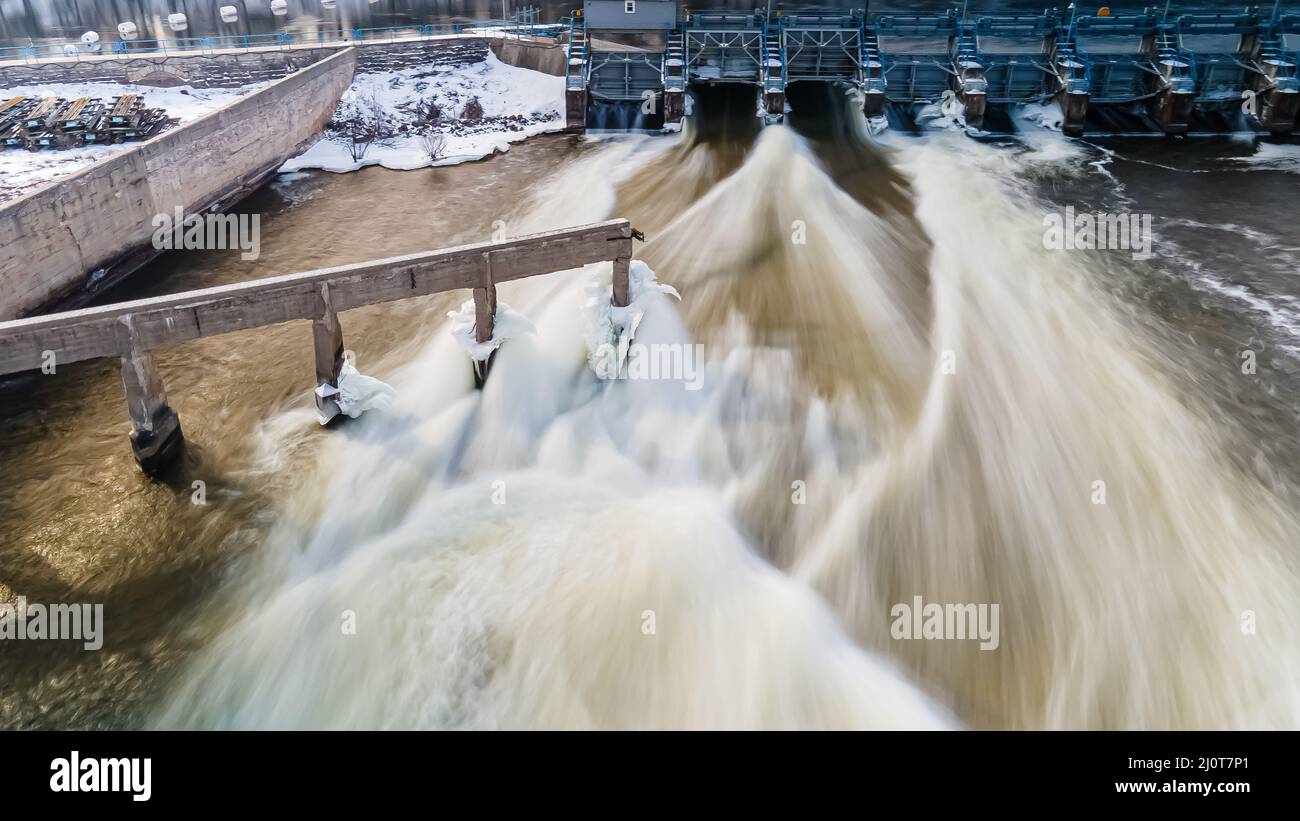 Water is rushing at the dam in winter as spring approaches with ...