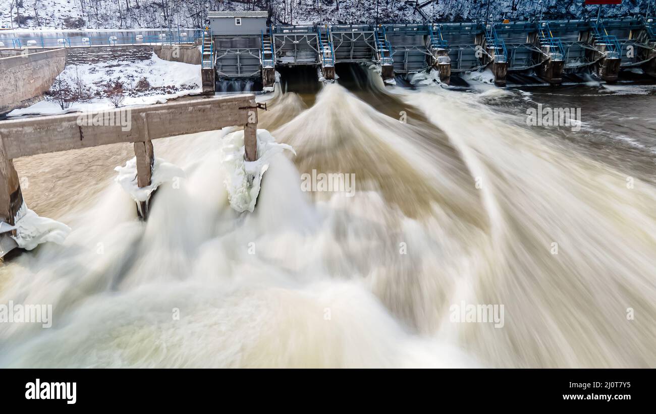 Water is rushing at the dam in winter as spring approaches with ...