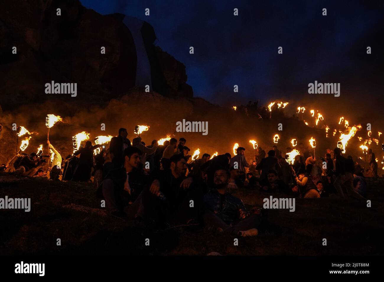 Akre, Iraq. 20th Mar, 2022. Iraqi Kurdish men hold fire torches as they ...