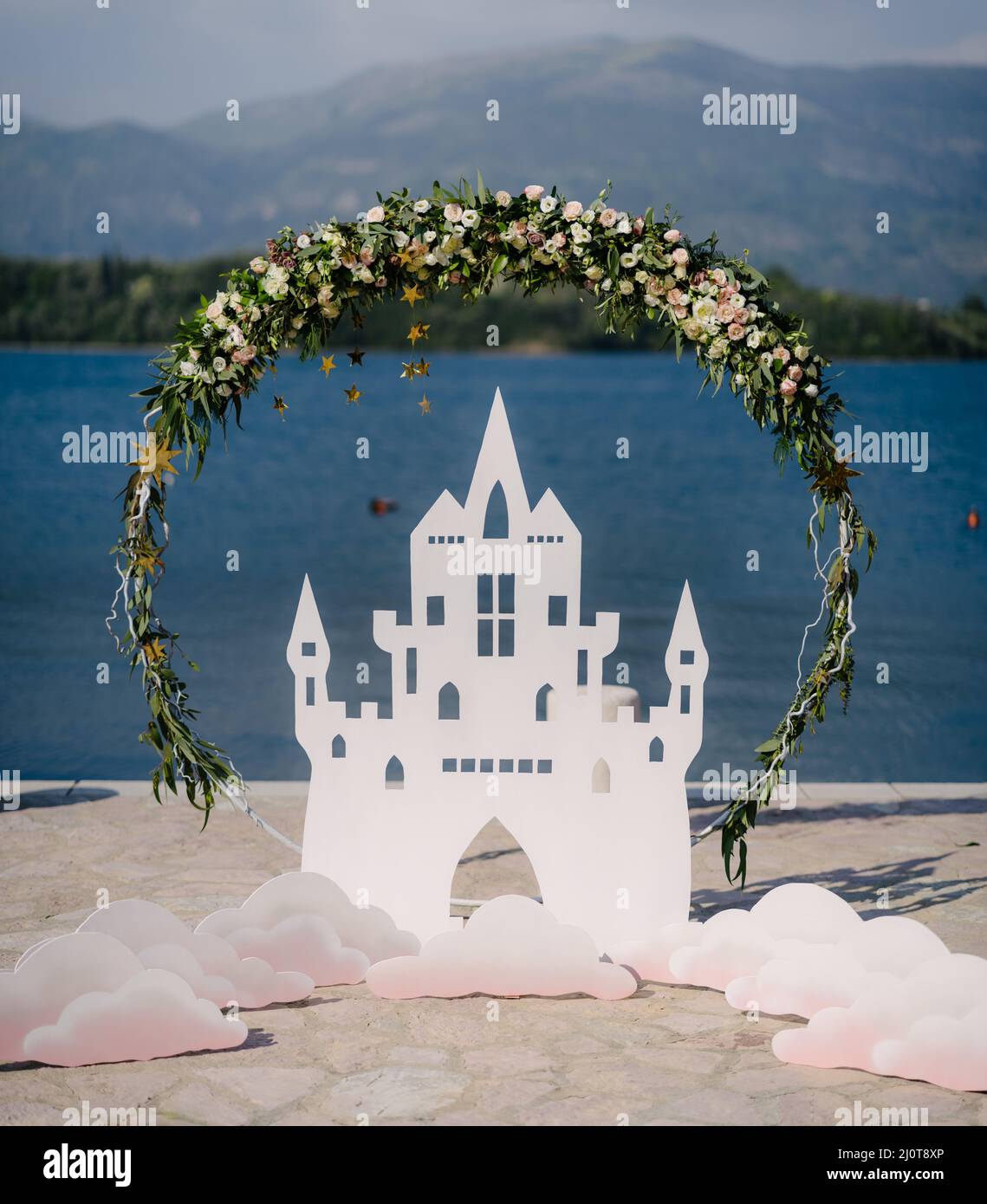 Wedding arch stands over a carved castle by the sea Stock Photo - Alamy
