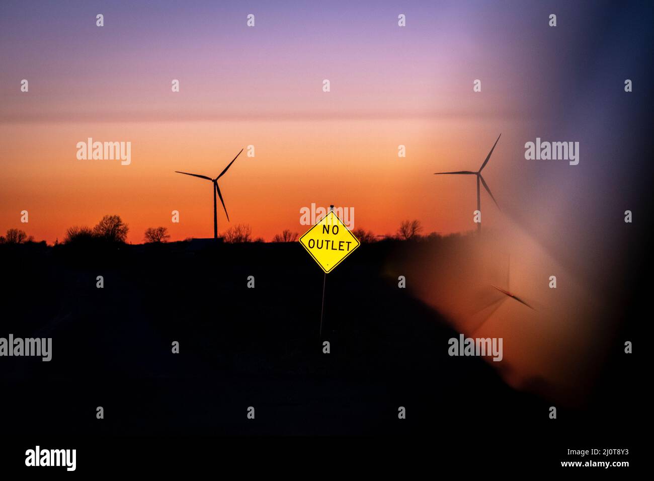 Wind turbines and a "No Outlet" sign along a rural road in the American ...
