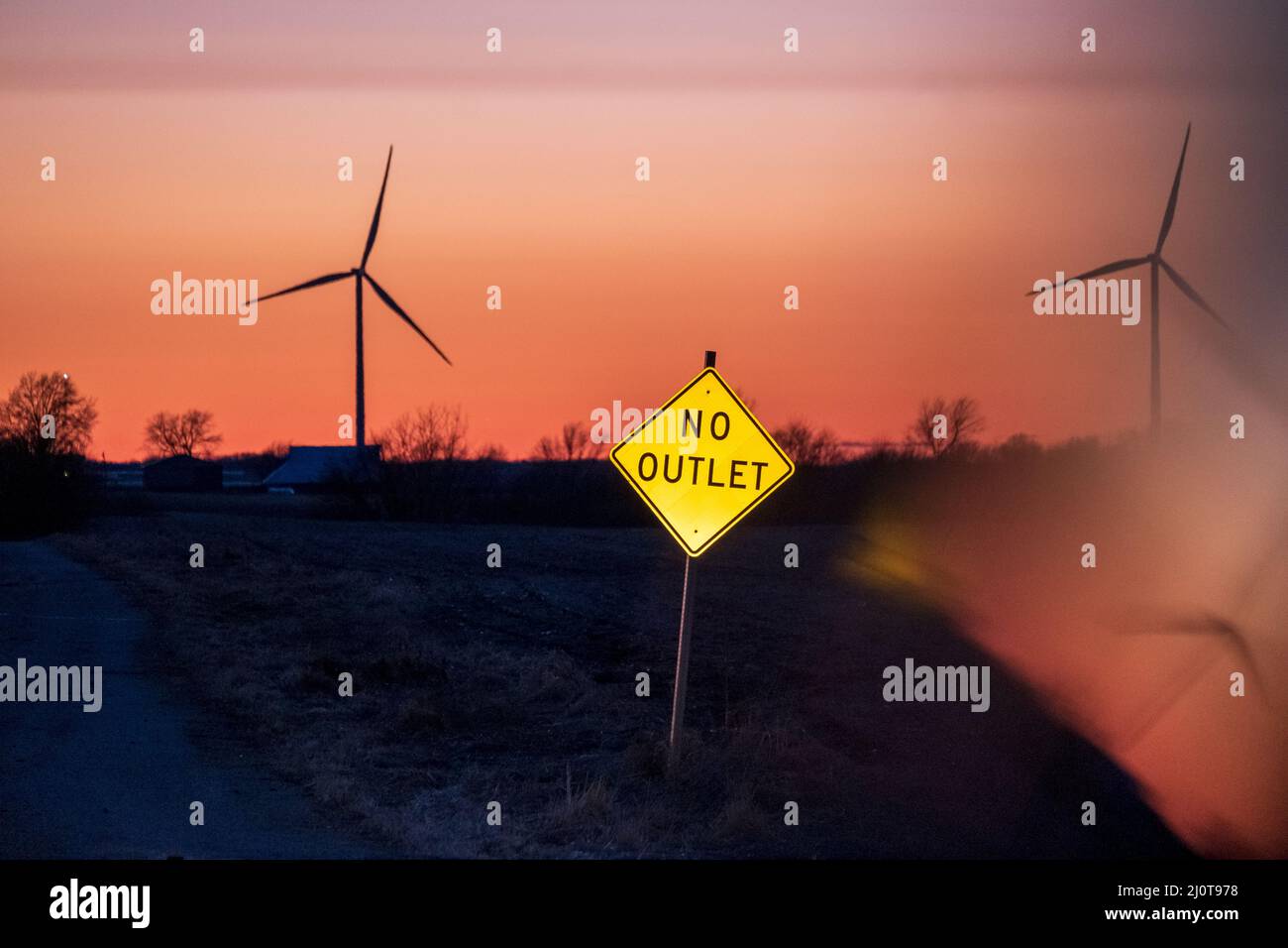Wind turbines and a "No Outlet" sign along a rural road in the American ...
