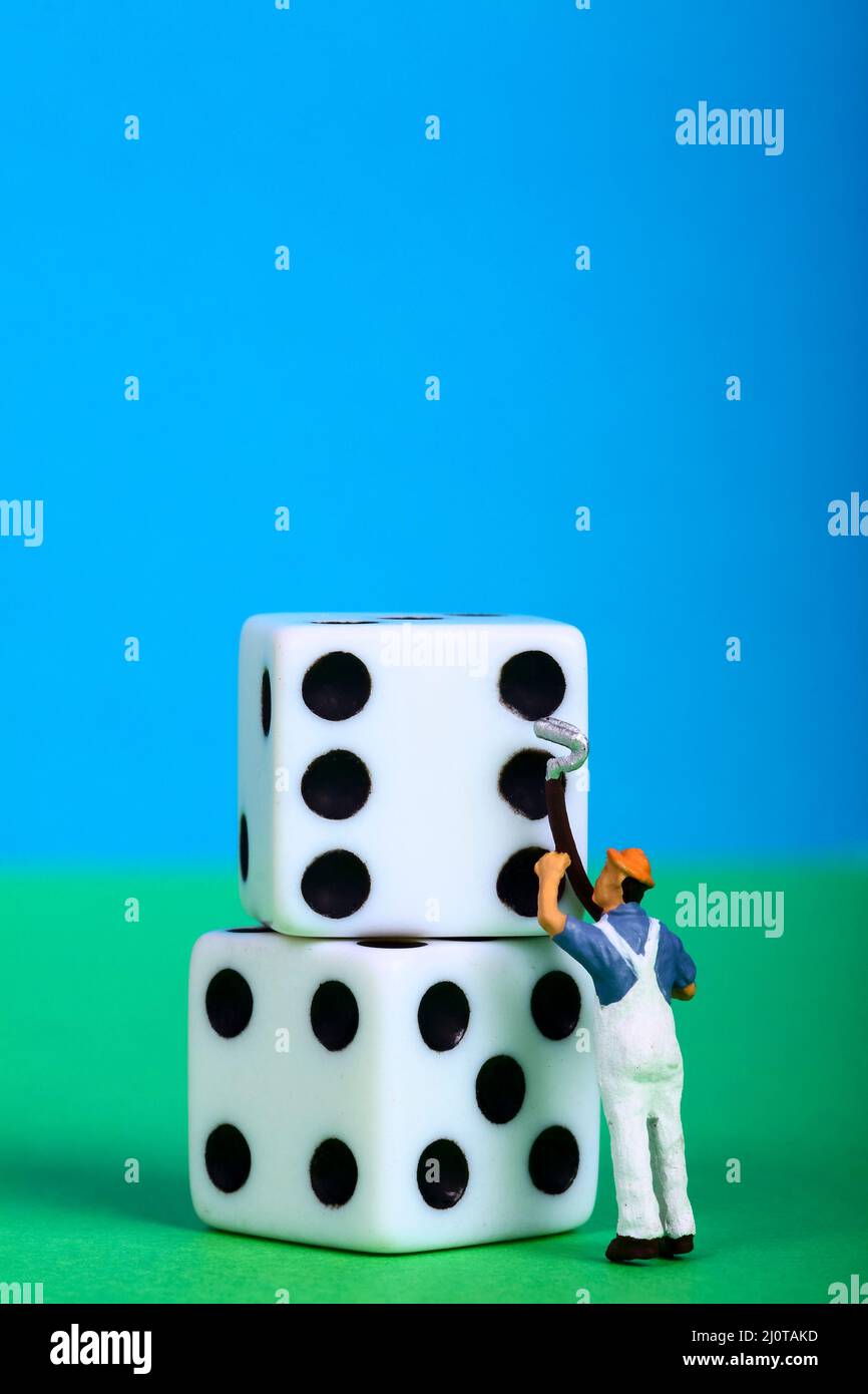 Conceptual image of miniature figure painting the spots on dice, change ...