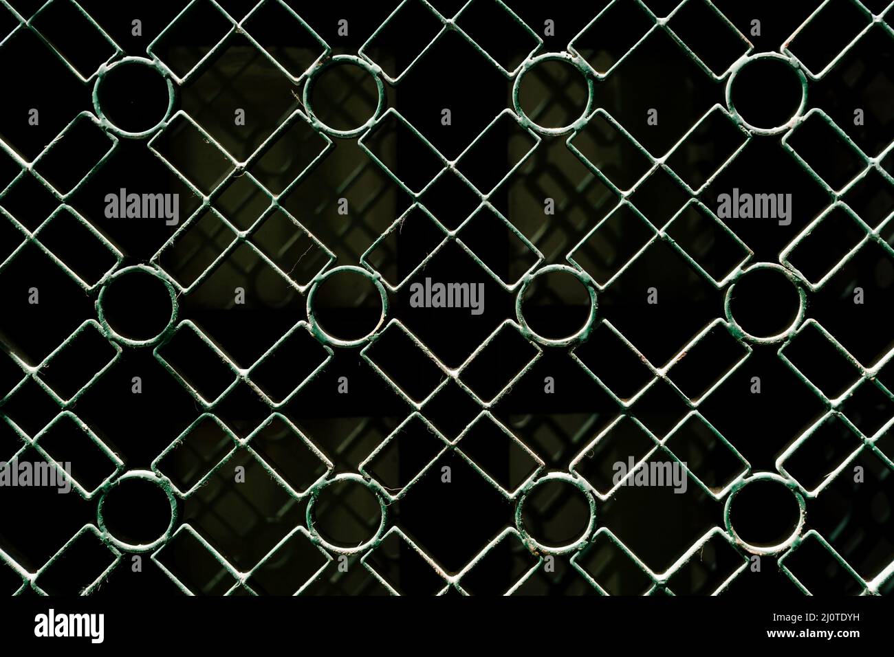 Fragment of a metal forged fence made of geometric shapes. Close-up ...