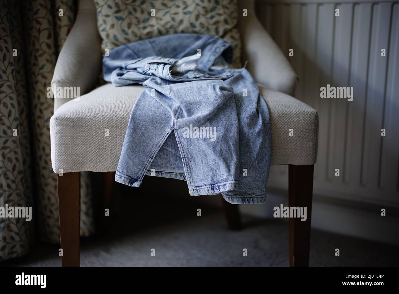 Clothes on an armchair in a room Stock Photo - Alamy