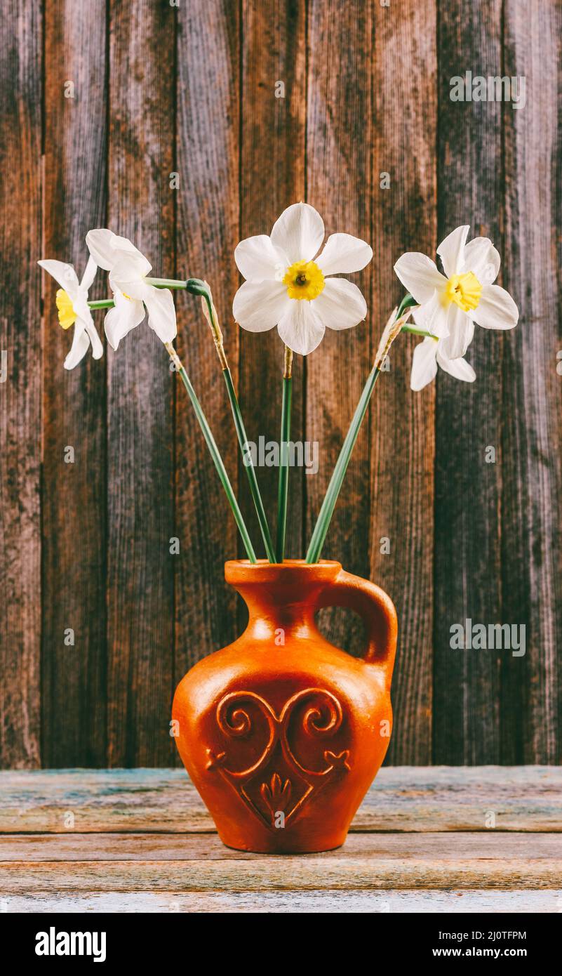 Still life of a bouquet of daffodils flowers in an old ceramic jug on a ...