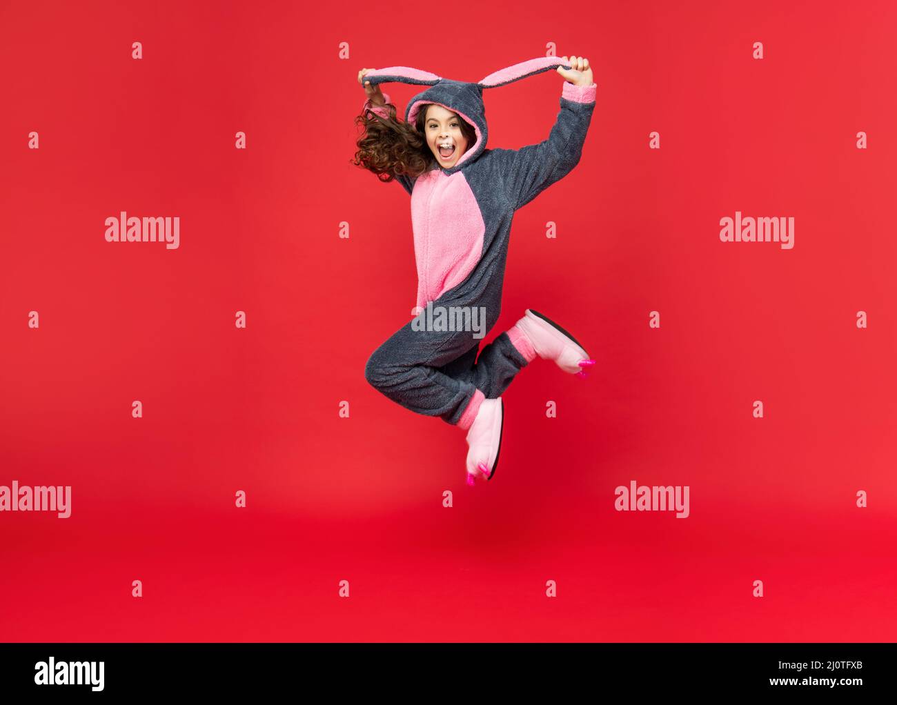 shouting teen girl in soft night suit jumping on red background, comfort Stock Photo - Alamy