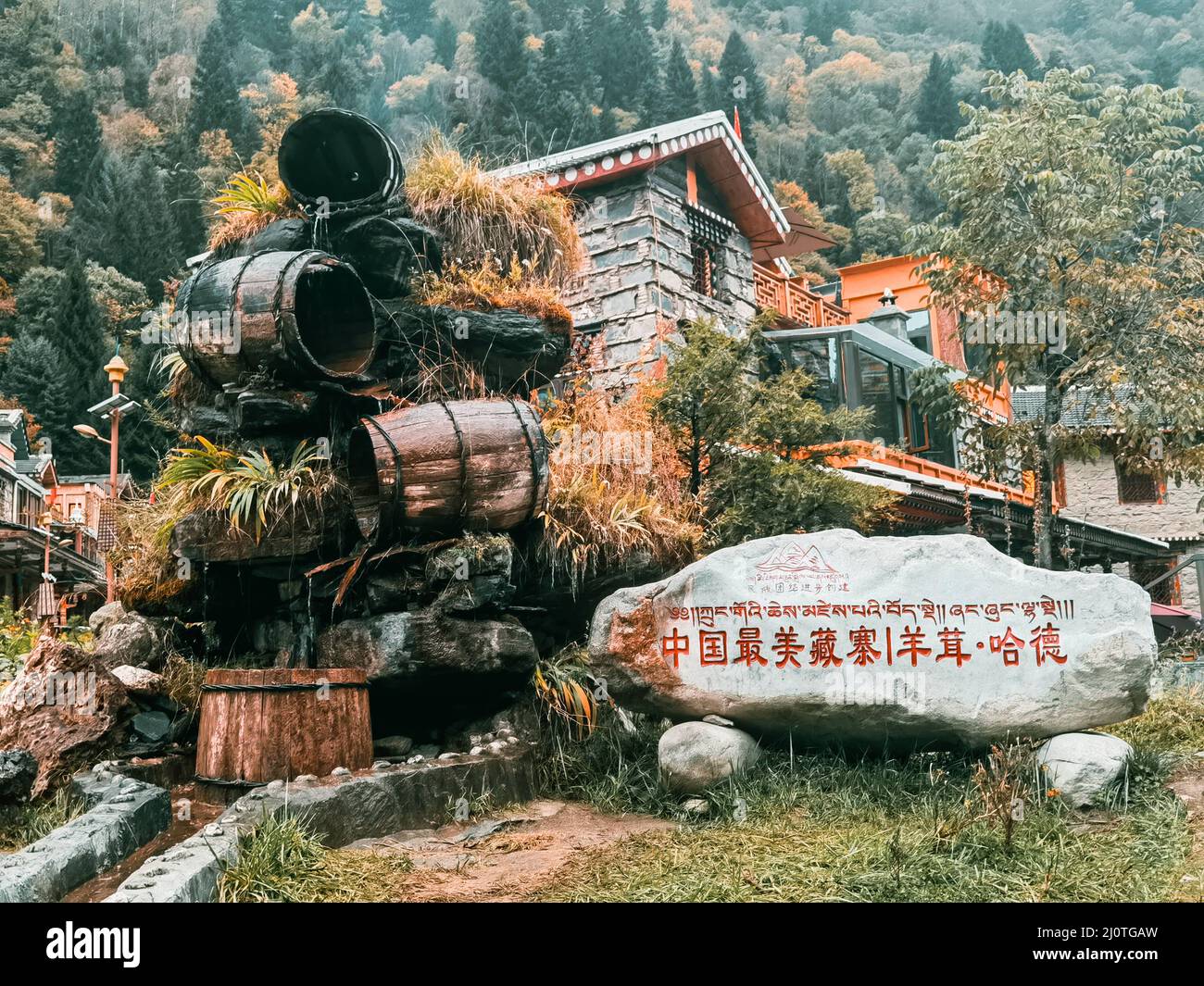 Closeup of a waterfall made of old barrels next to a big rock with a ...