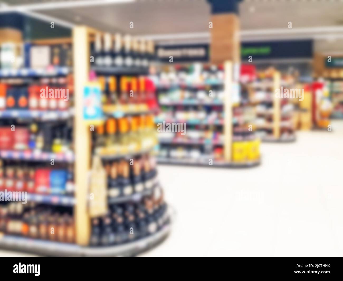 Blurred abstract background with racks with bottles of alcoholic ...
