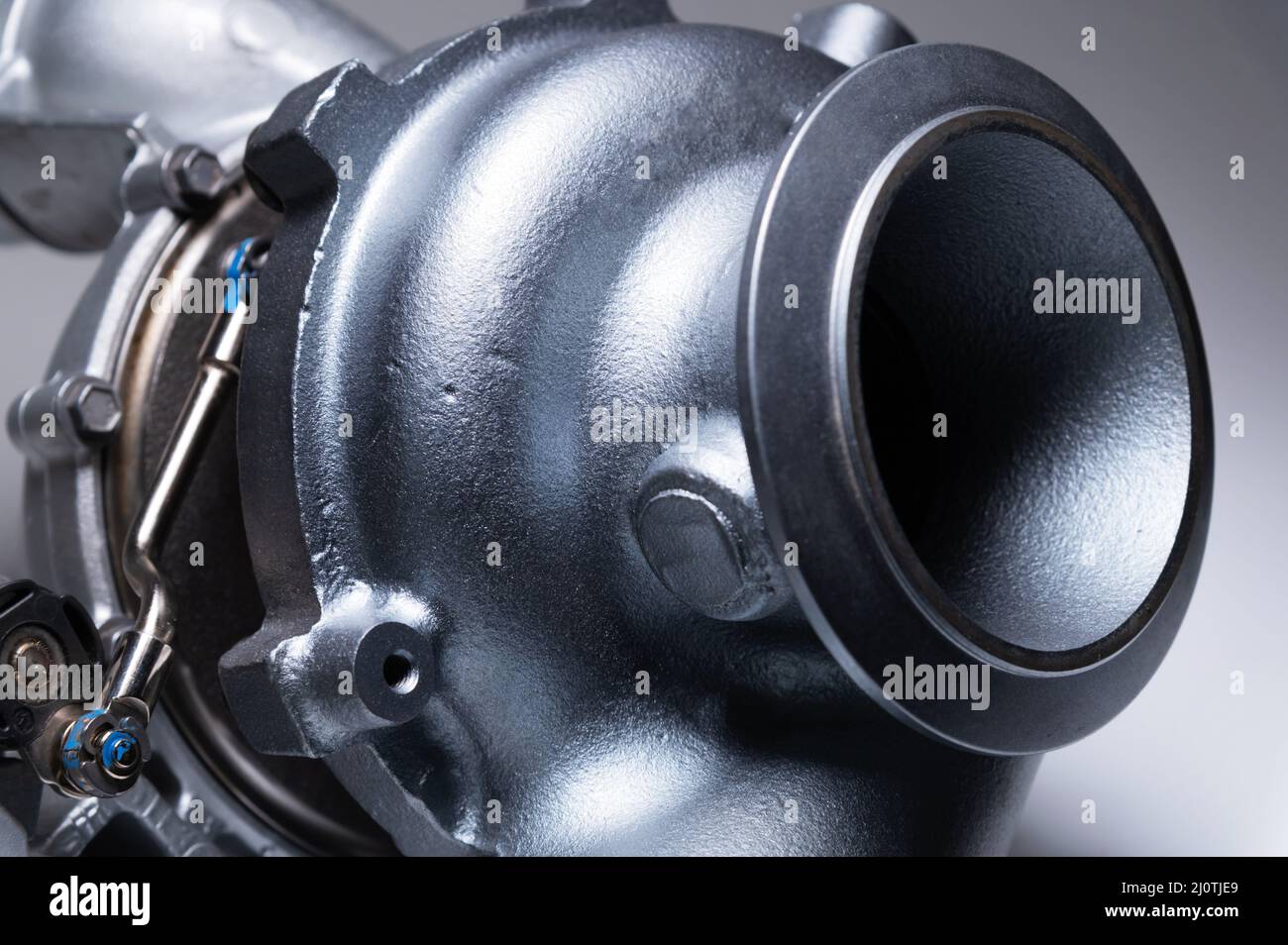 Auto parts new mechanical turbine made of metal on a gray background ...