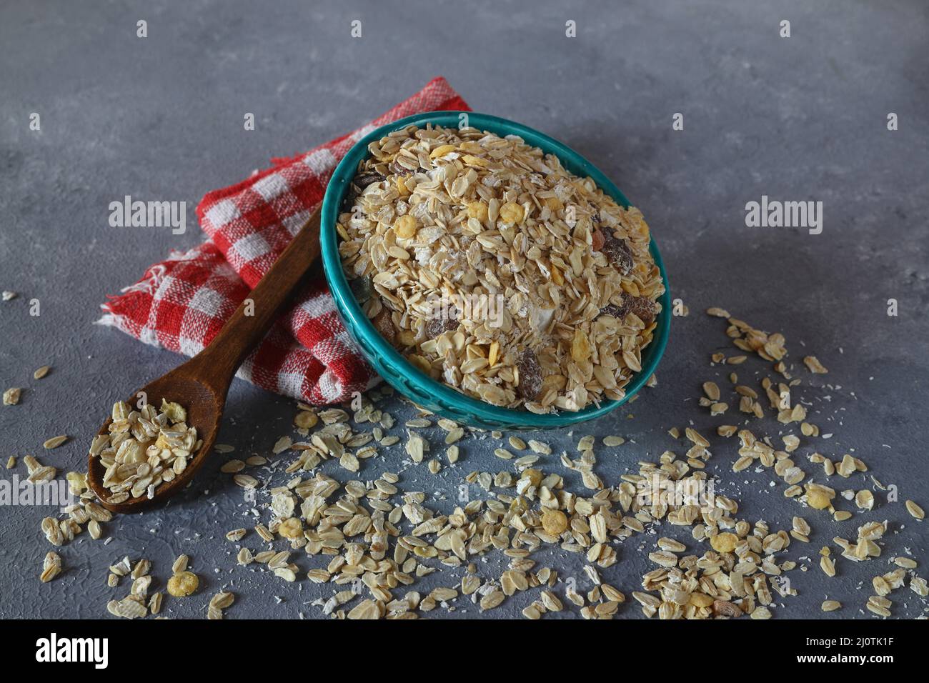 Oat flakes uncooked in a green bowl on rustic table. Healthy food for ...