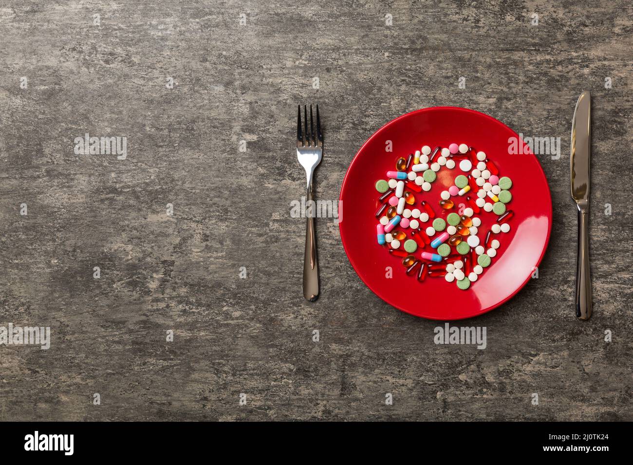 Many different weight loss pills and supplements as food on round plate ...