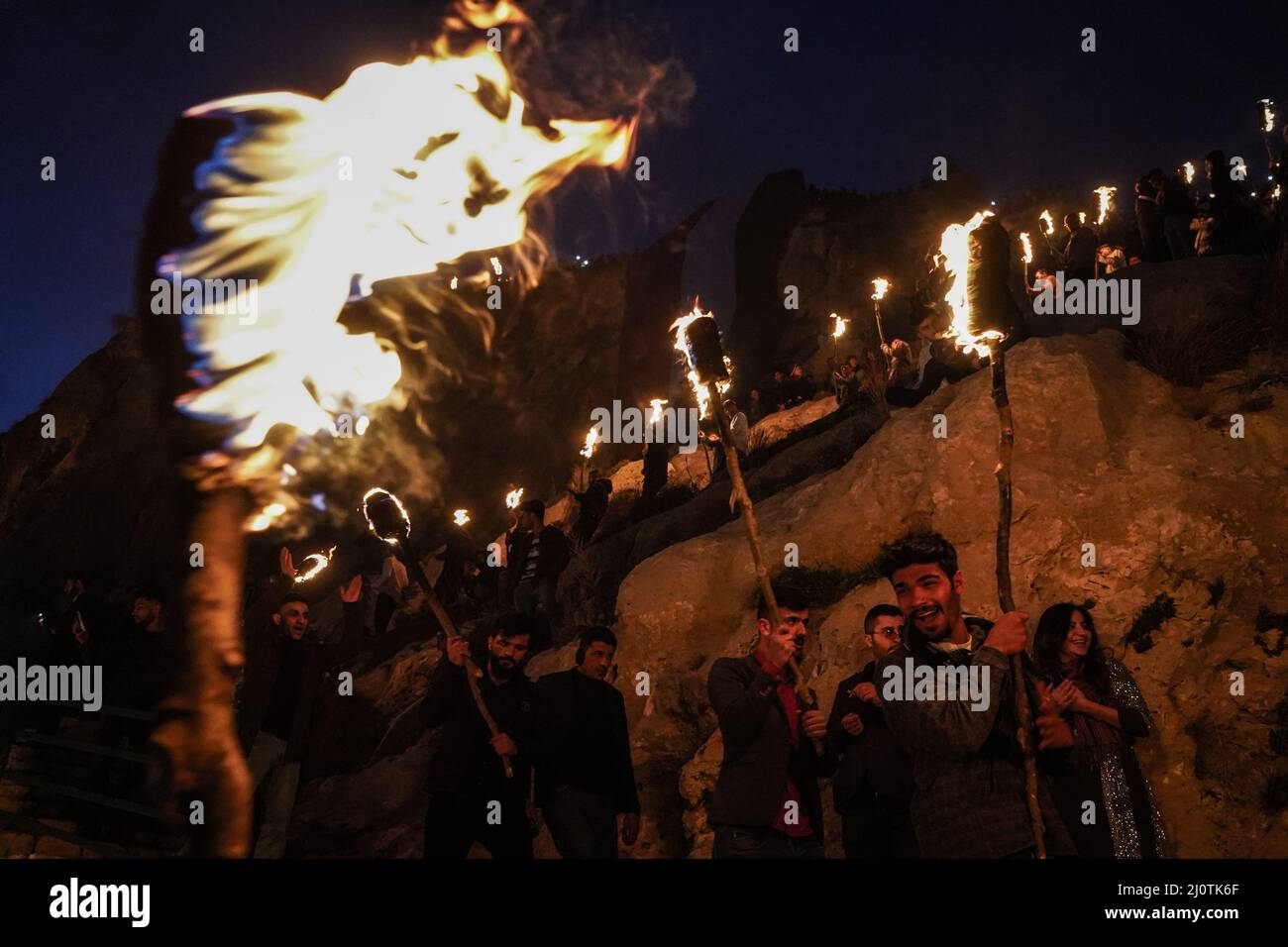 Akre, Iraq. 20th Mar, 2022. Iraqi Kurdish men hold fire torches as they ...