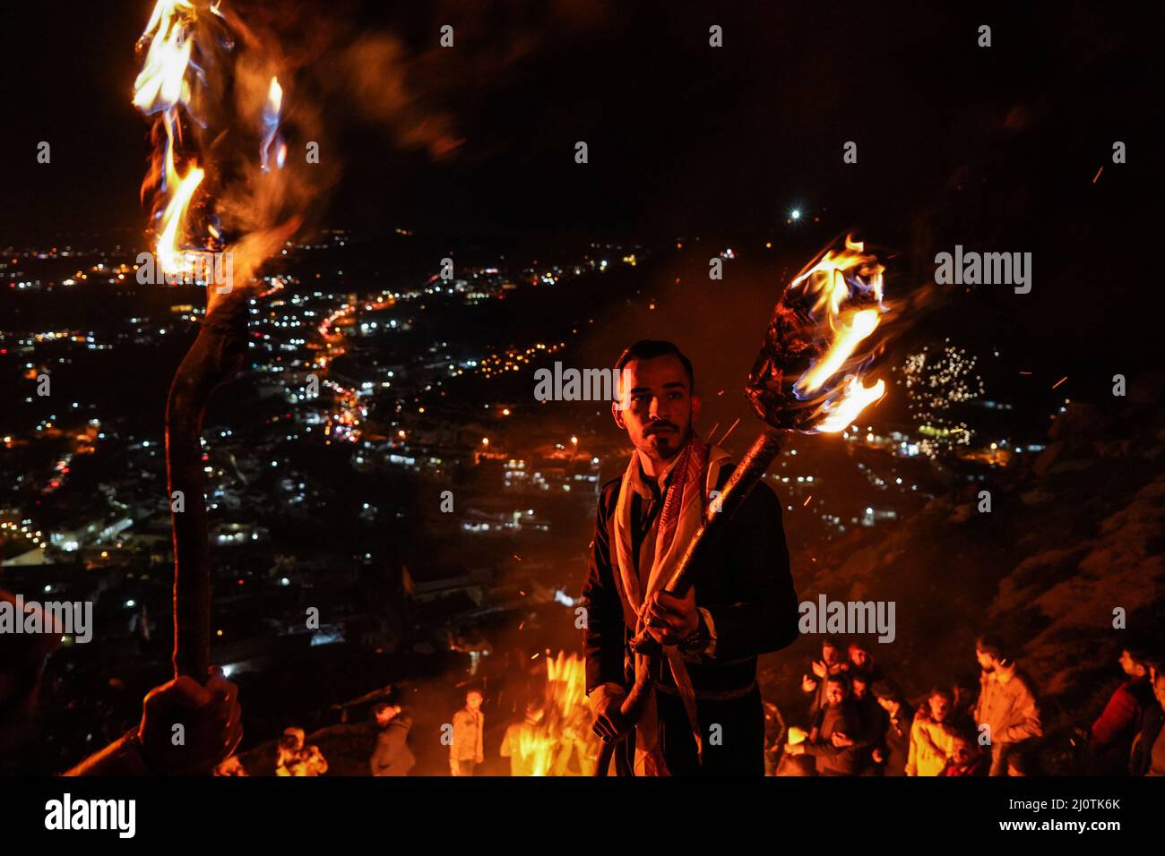 Akre, Iraq. 20th Mar, 2022. Iraqi Kurdish men hold fire torches as they ...