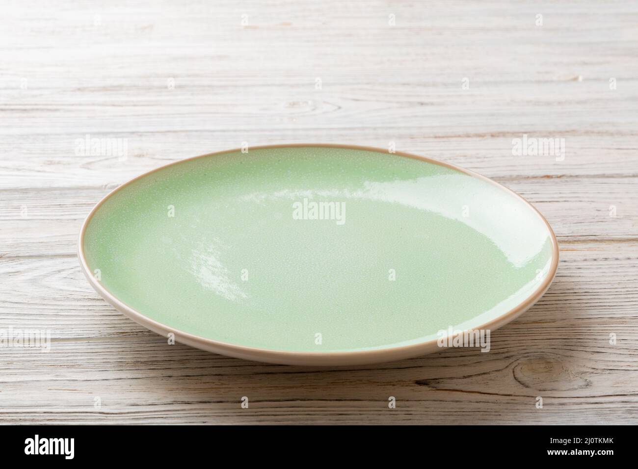 Perspective view of empty green plate on cement background. Empty space ...