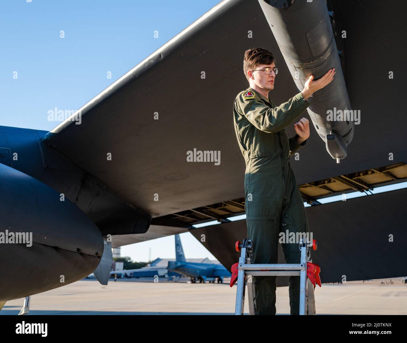 An aircrew member from the 96th Bomb Squadron inspects a wing mounted ...