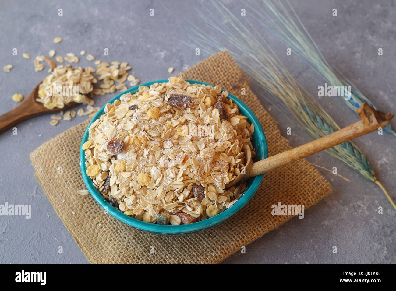 Oat flakes uncooked in a green bowl on rustic table. Healthy food for ...