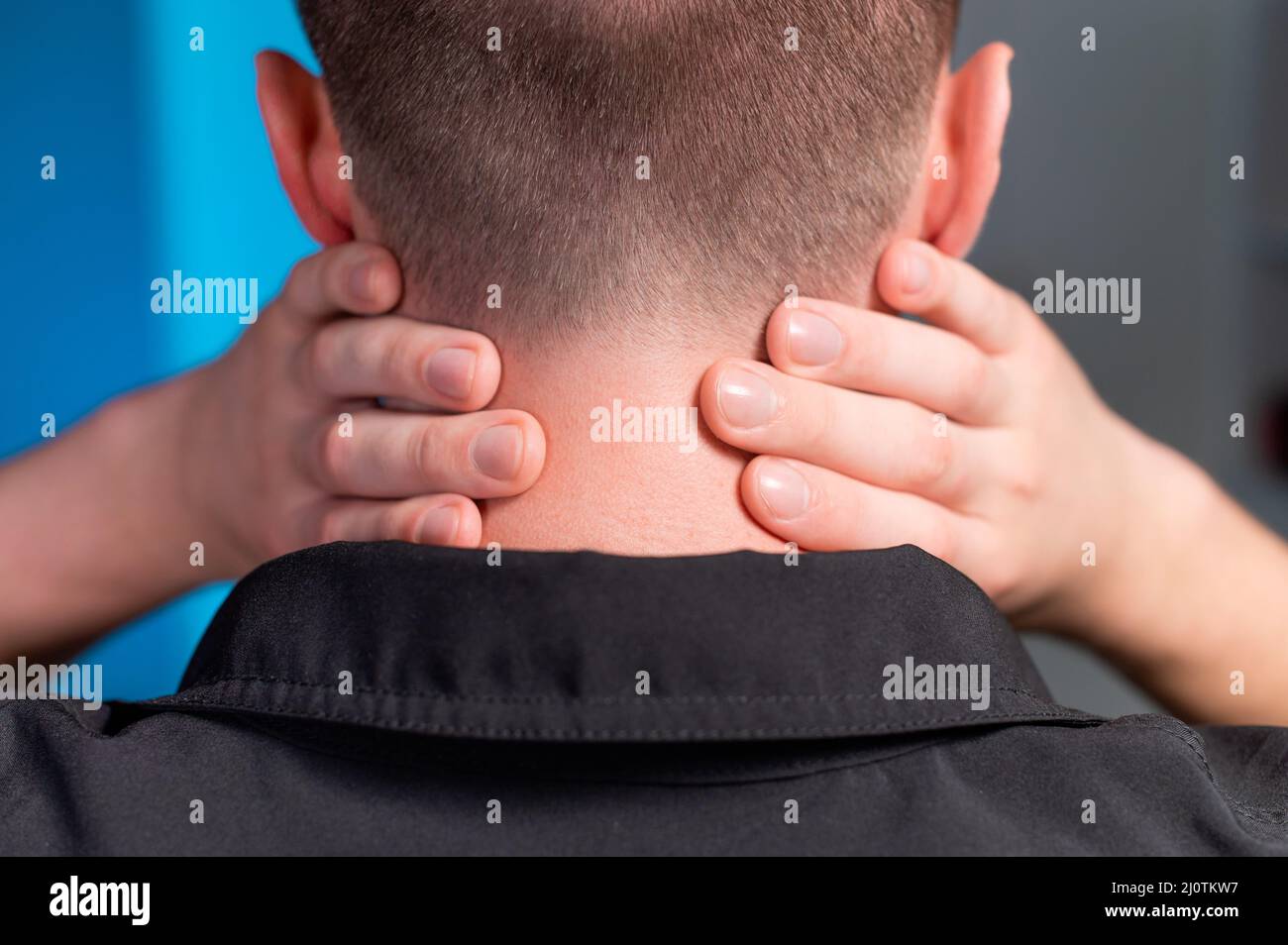 Close-up of a man holding his neck with his hands. Neck pain and self ...