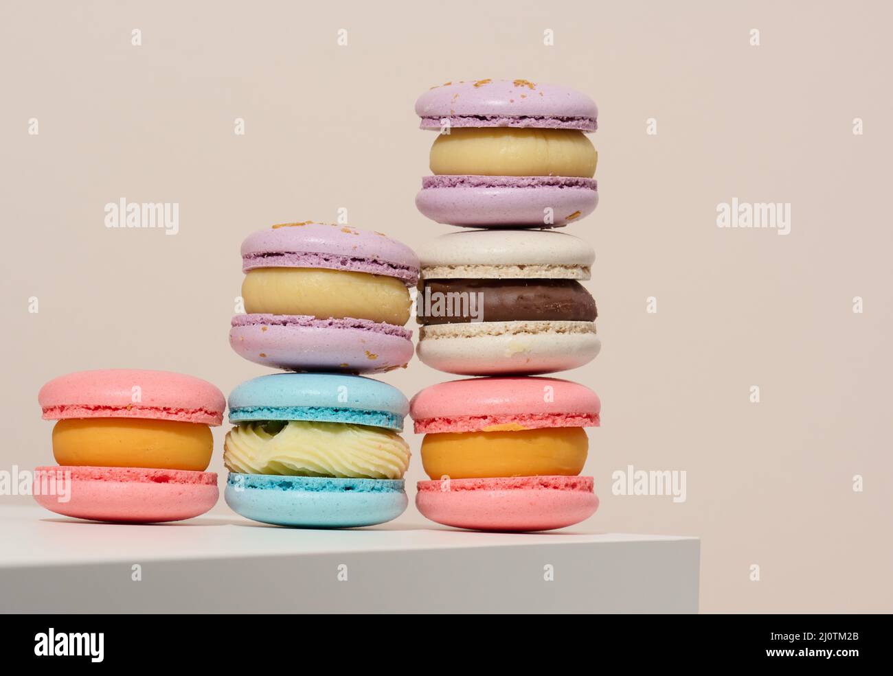 Baked round macarons on a beige background, delicious dessert, bottom ...