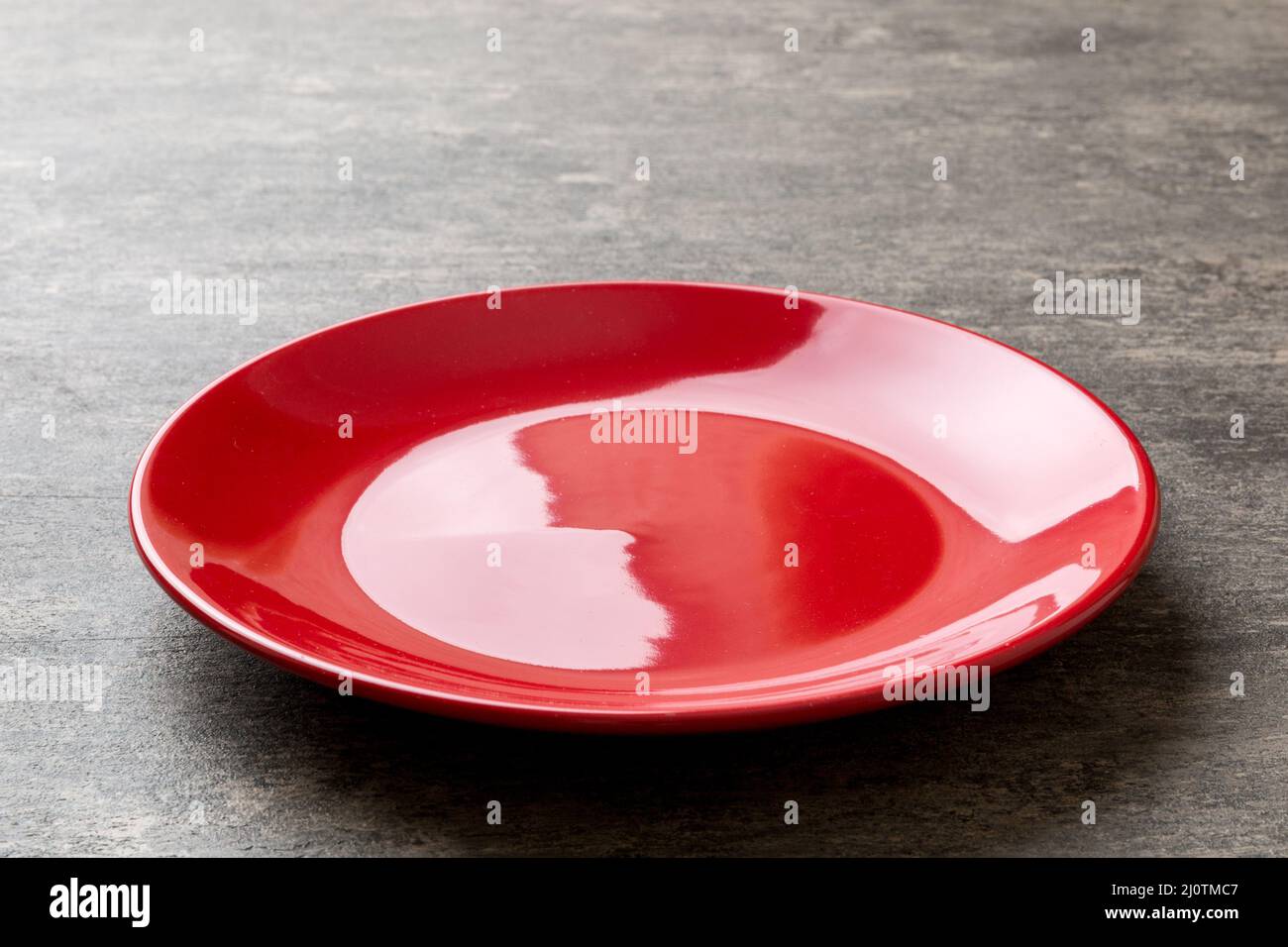 Perspective view of empty red plate on cement background. Empty space ...