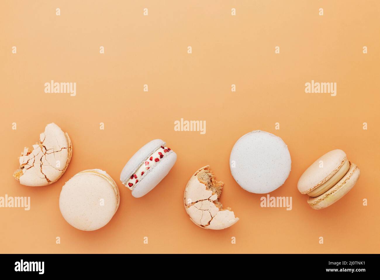 White, yellow, gold macaron cookies. Colorful, sweet small French ...