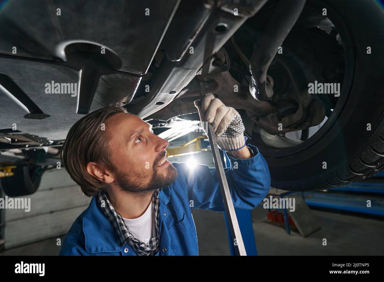 Man holding tool and repairing car at service station Stock Photo - Alamy